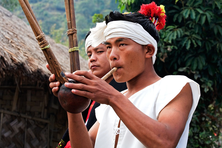 Young man of the Kuki naga clan playing a wind instrument